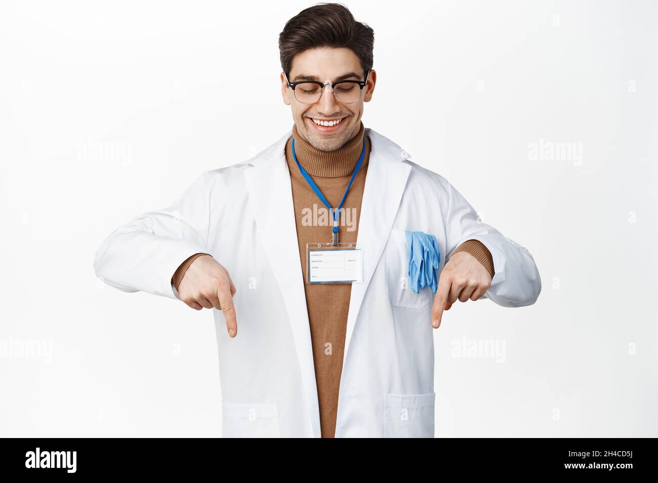Smiling medical worker, doctor pointing and looking down with happy ...