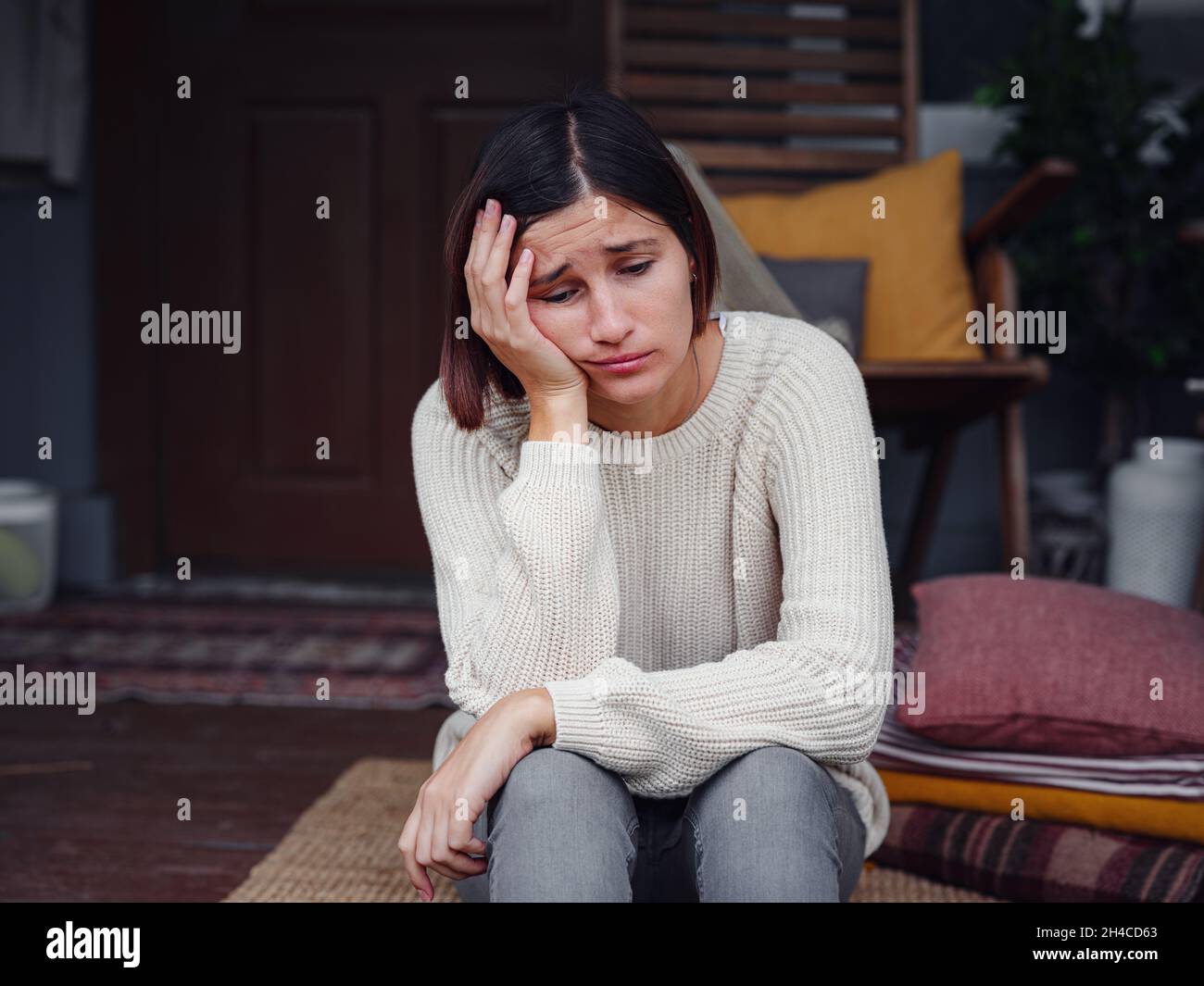 Young depressed asian woman sitting on porch of backyard. She feeling ...