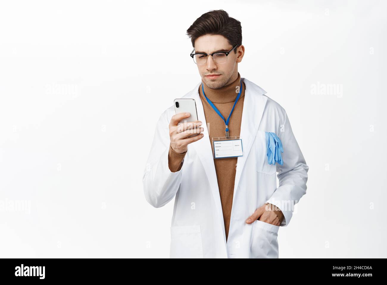 Serious doctor reading on mobile phone app, checking in with patient ...
