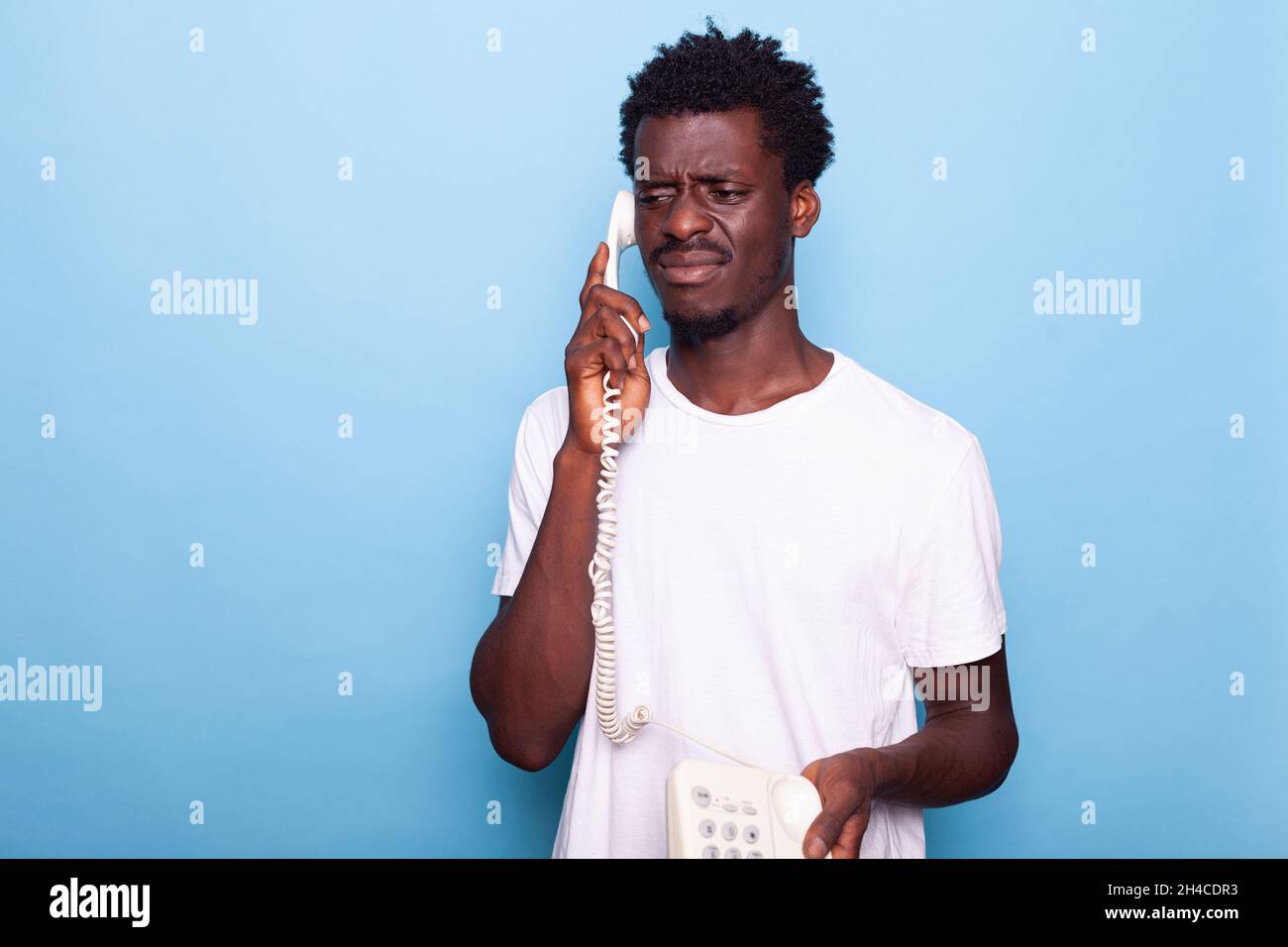 Man answering retro landline phone while posing. Young person with ...
