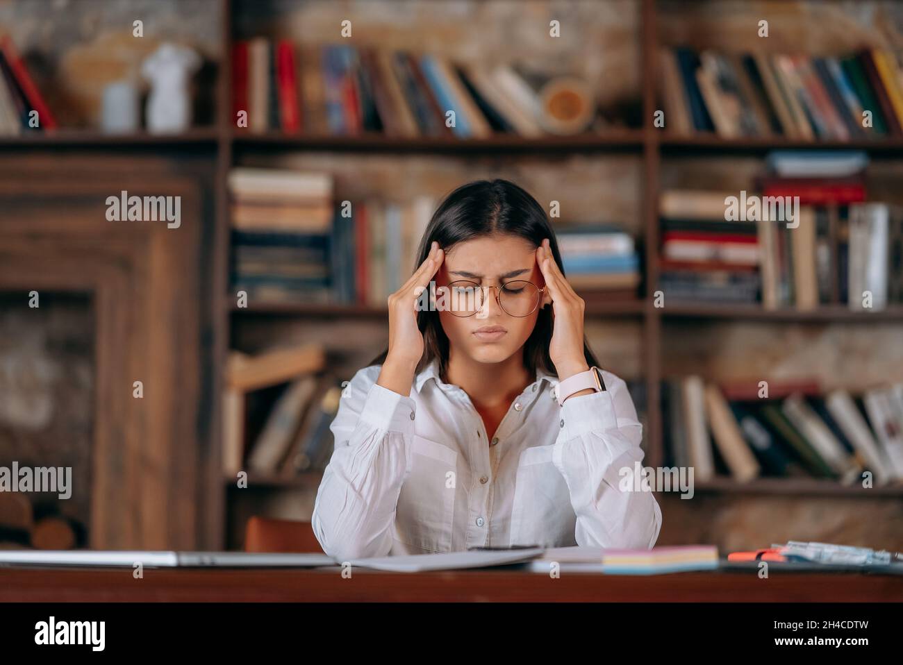Young woman in office thinking over problem on background of ...
