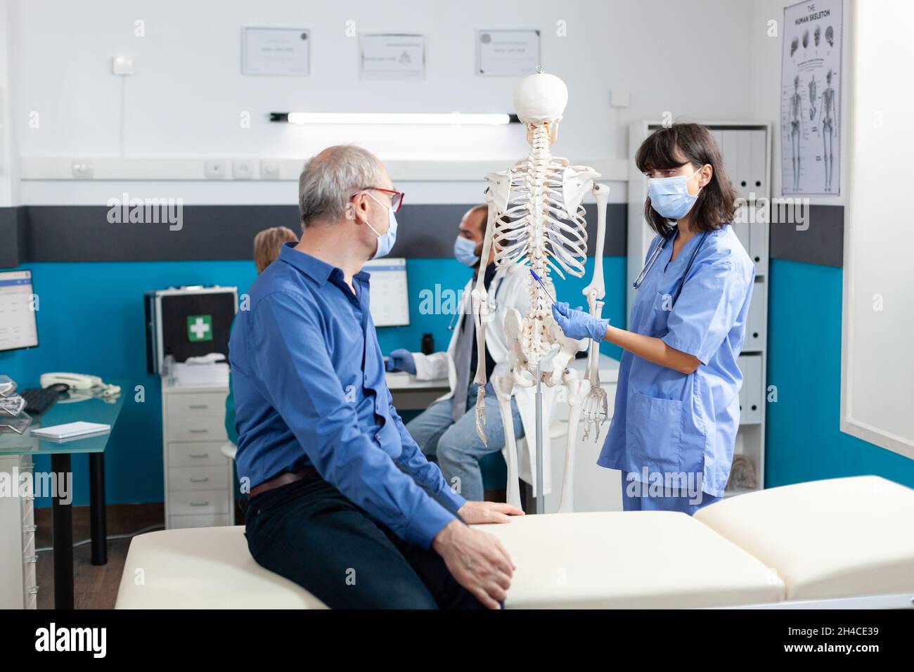 Senior man looking at human skeleton for chiropractic care. Medical ...