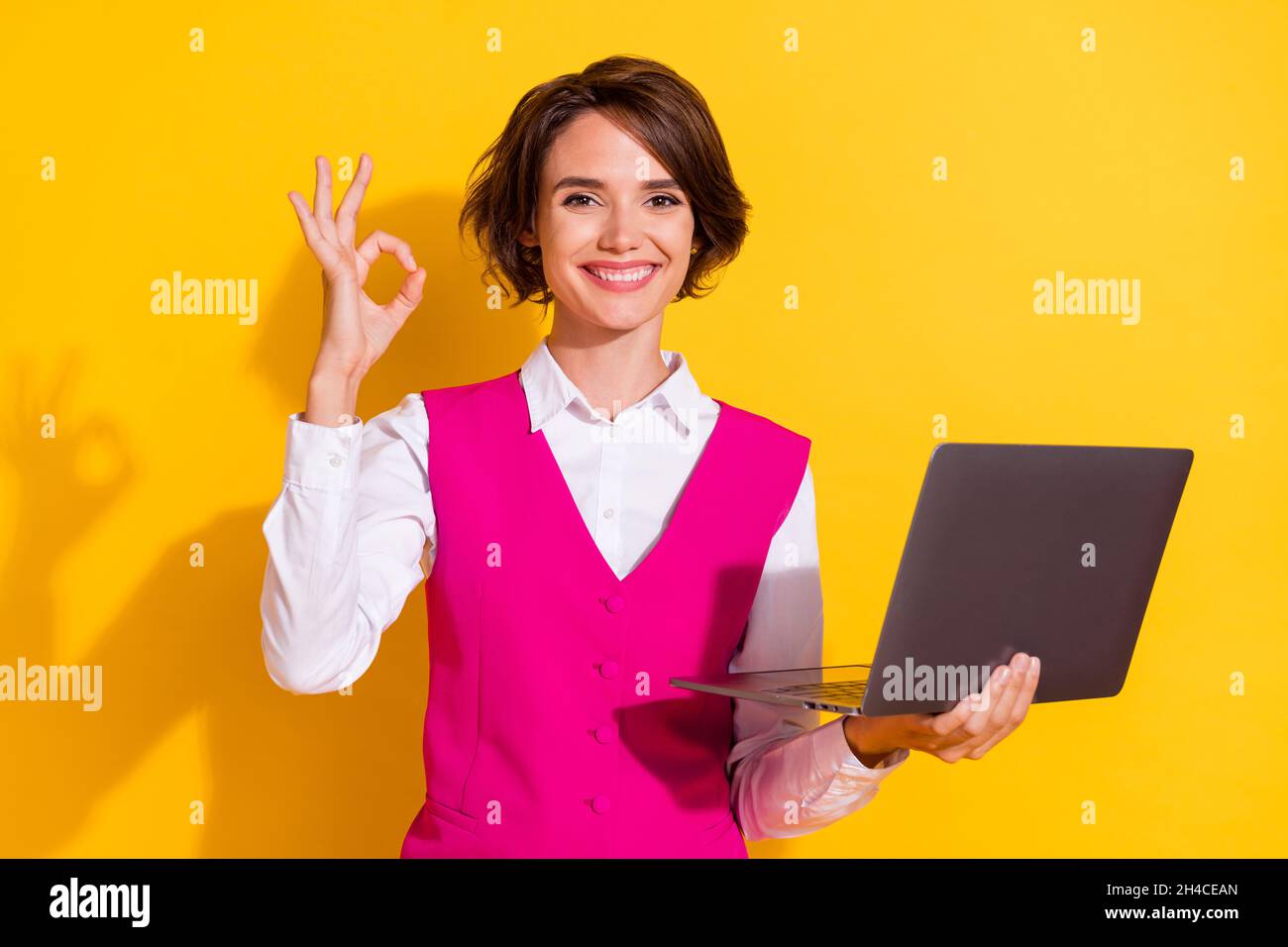 Photo of excited shiny young lady wear pink suit holding modern device ...