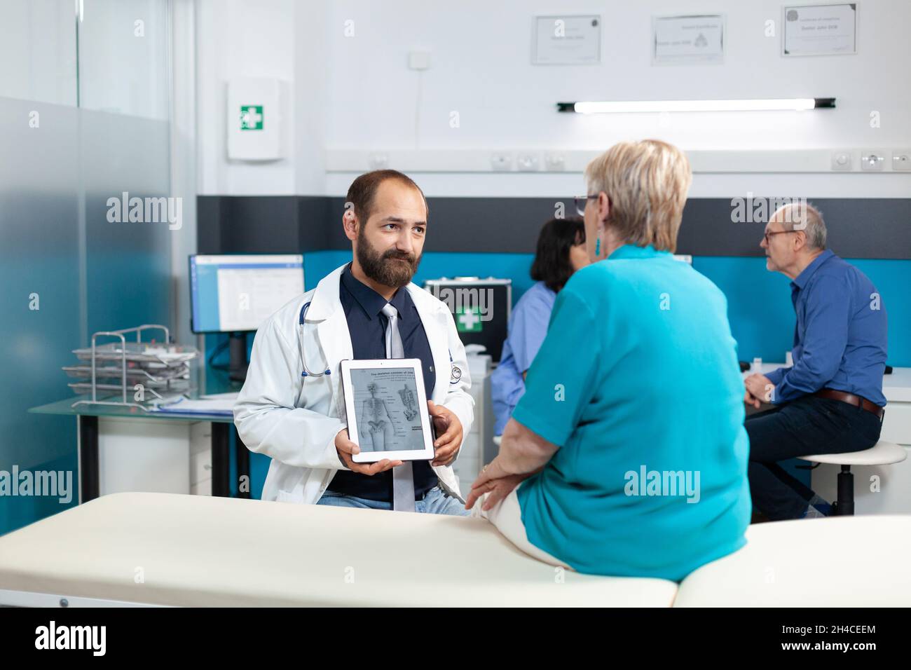 Doctor showing human skeleton image on modern tablet for osteopathy ...