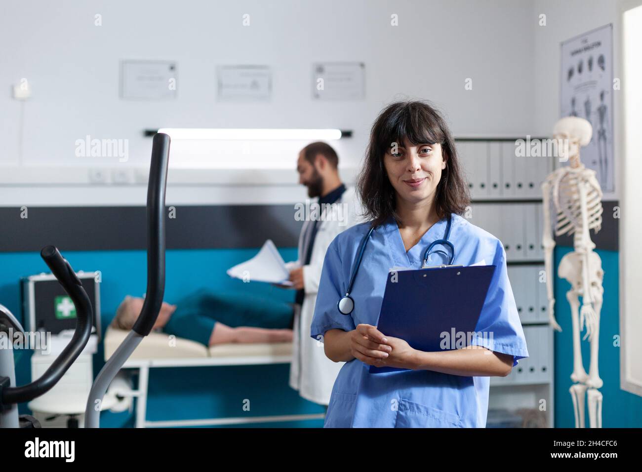 Portrait of medical assistant standing in physiotherapy office. Woman ...