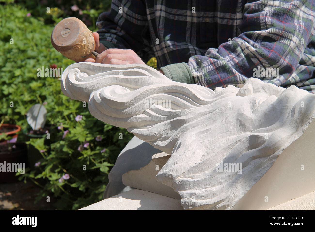 A Craftsman Using a Chisel to Carve a Stone Head Stock Photo - Alamy