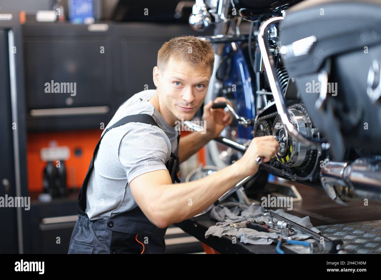 Male mechanic in a garage repairing a motorcycle Stock Photo - Alamy