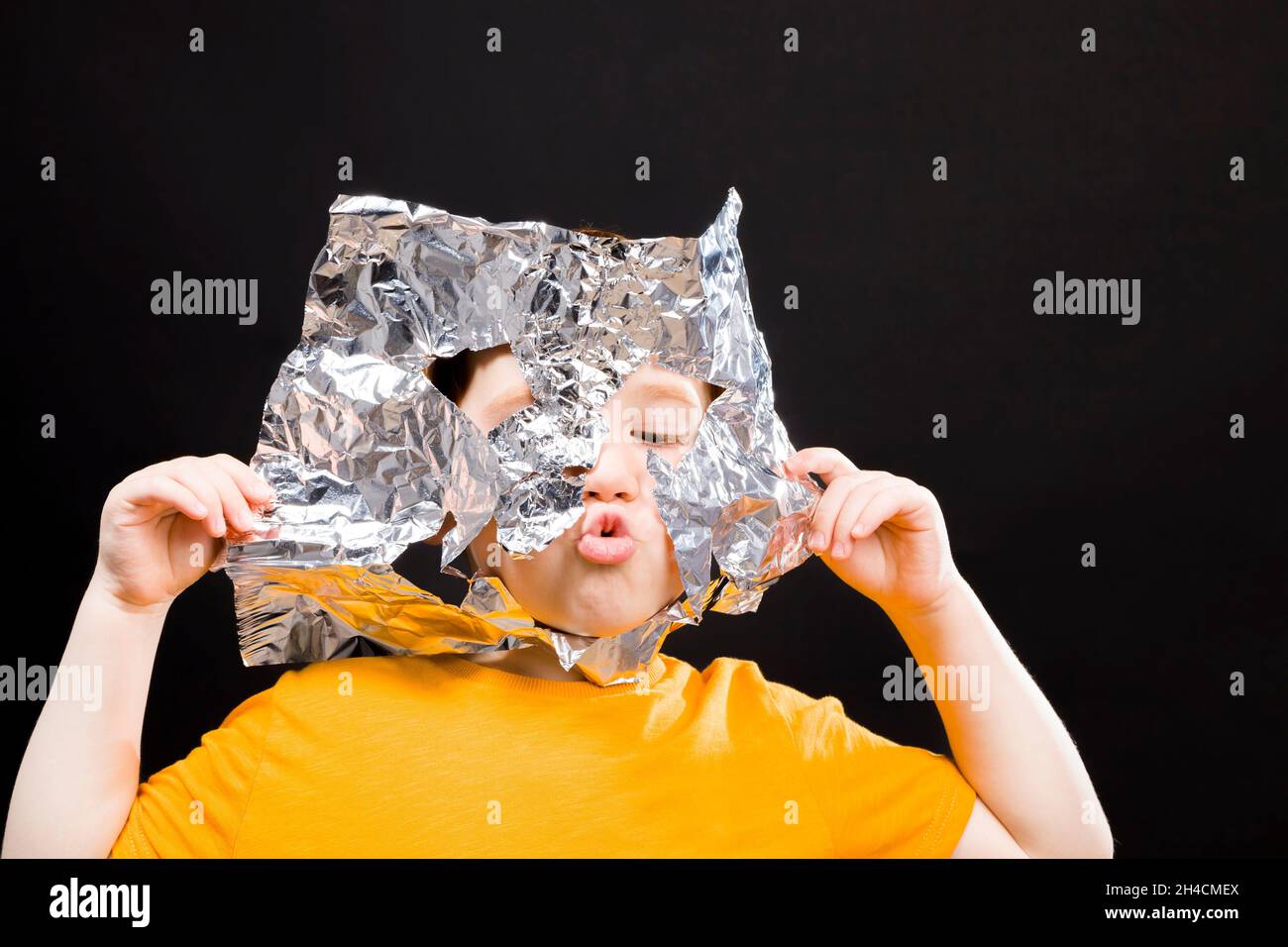 the boy creates different things from foil, including hats that he puts ...