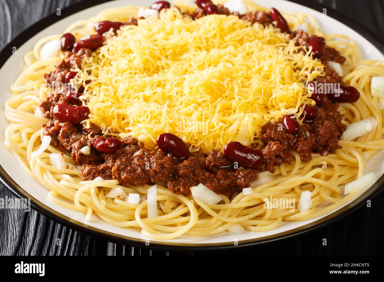Cincinnati style chili 5 way close up in the plate on the black wooden ...