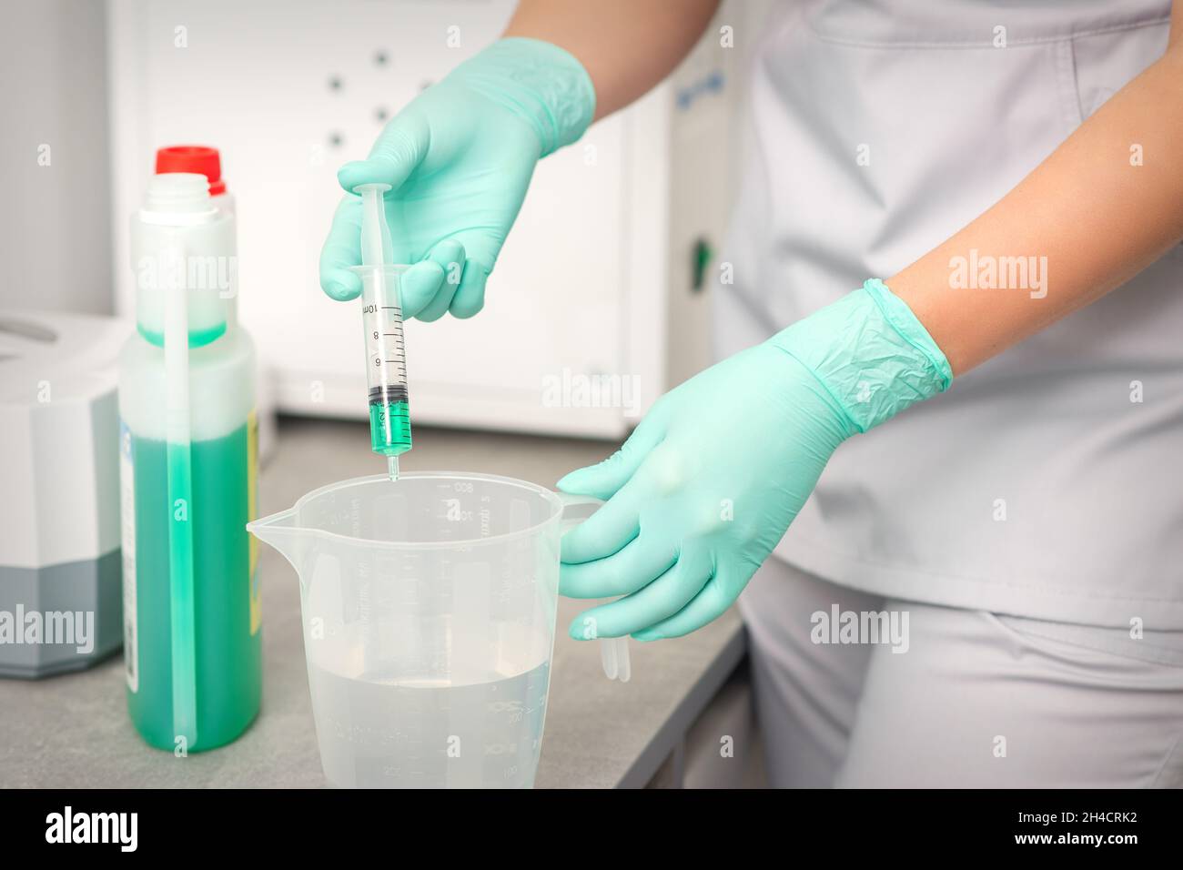 The beautician uses a syringe to add disinfectant to the water ...