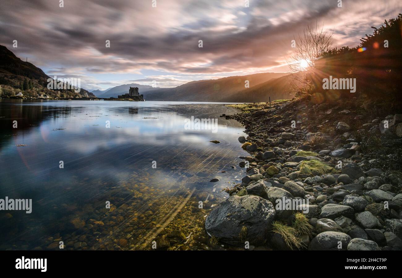 Sunsets behind the hills overlooking Eilean Donan Castle, Wester Ross ...