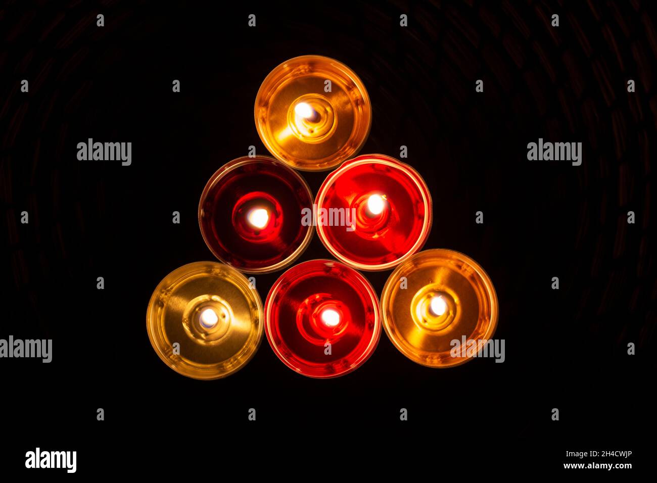 The candles are laid out in a triangle. Candles burn in the dark. Red ...