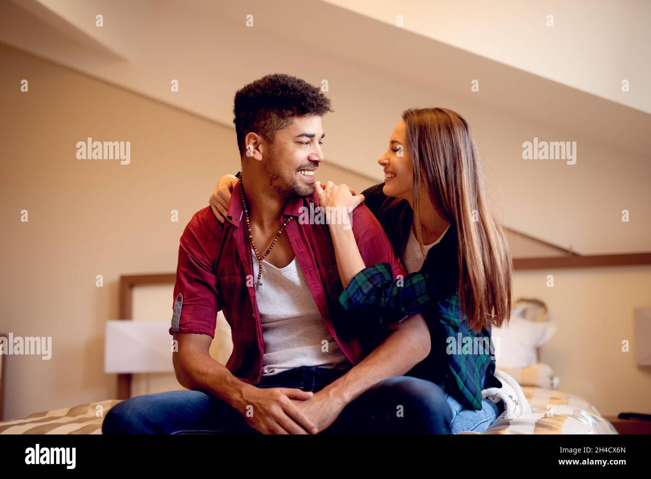 Beautiful couple in bedroom, woman embracing her partner in bed Stock ...