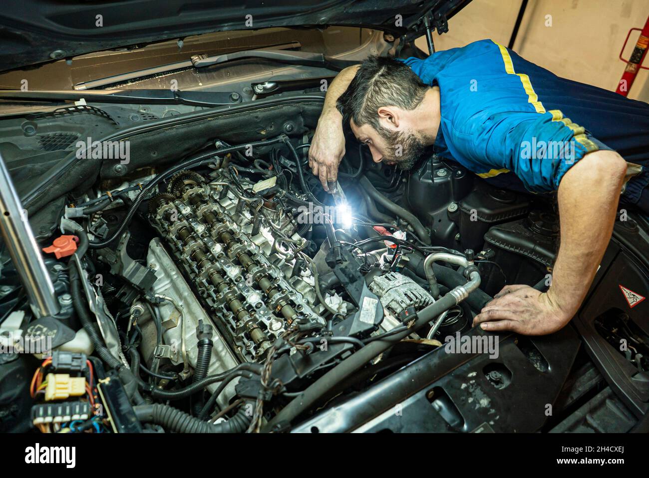 Auto mechanic and car engine part close-up. Side view Top view of a six ...