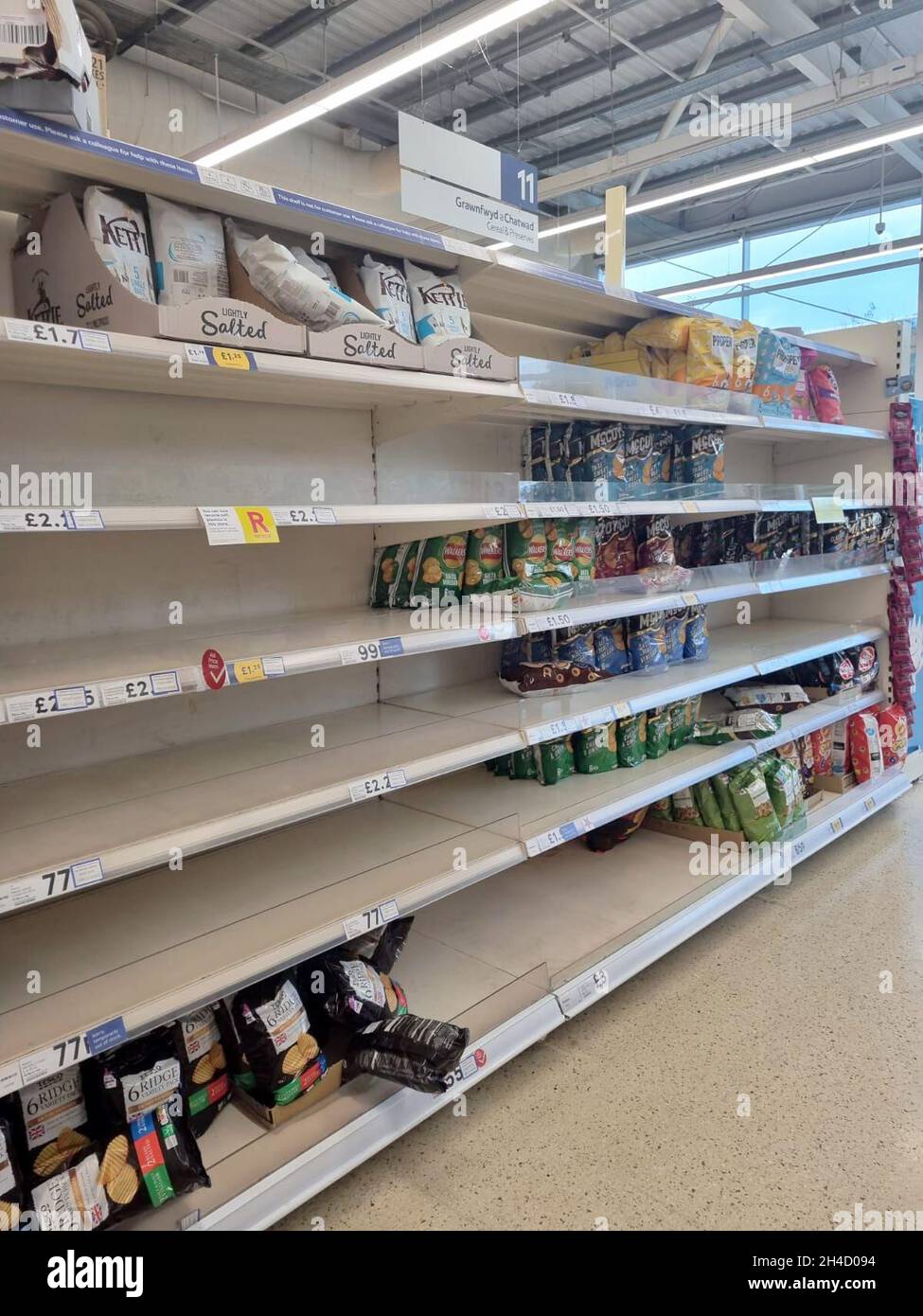 Empty spaces on a crisps shelf in a Tesco supermarket in Swansea, as ...