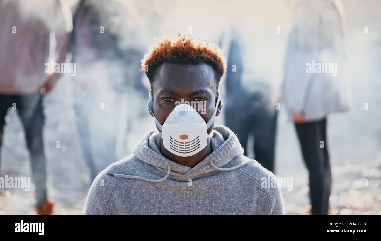 Portrait of a Sad Black Young Man in Gas Mask Standing in Toxic Smoke ...