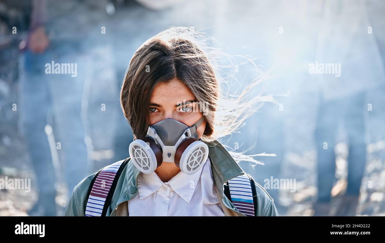 Portrait of Sad Young Woman in Gas Mask Standing in Toxic Smoke. Saving ...