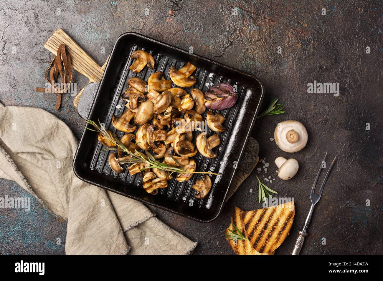 Top view of grilled champignon mushrooms on cast iron skillet or pan ...