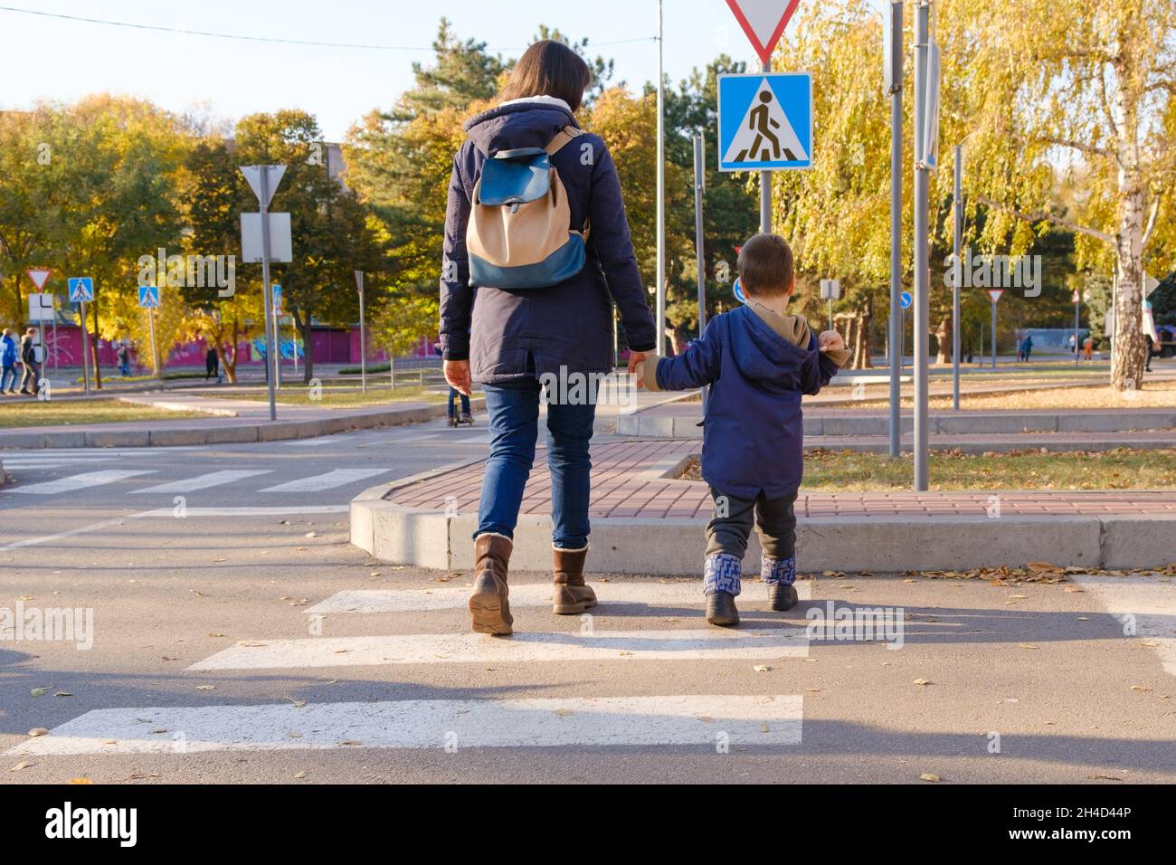 Mom and child cross the road at the zebra crossing Stock Photo - Alamy