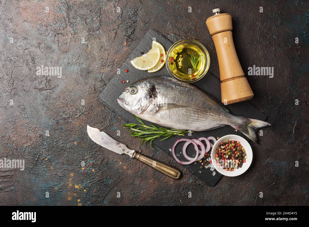 Top view of fresh fish dorado or gilt-head bream with lemon, olive oil ...