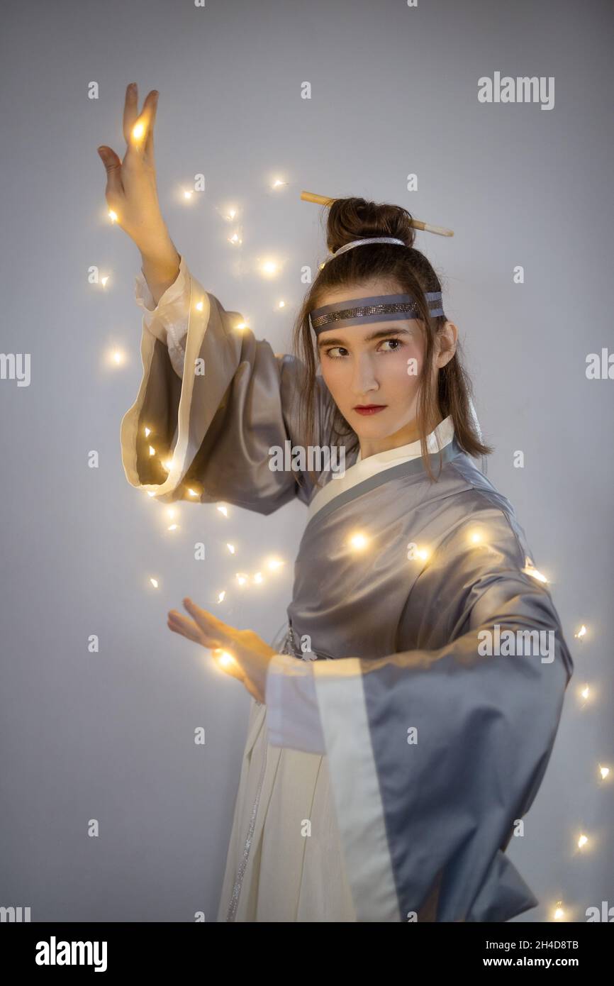 Caucasian woman posing in traditional Chinese hanfu dress holding ...
