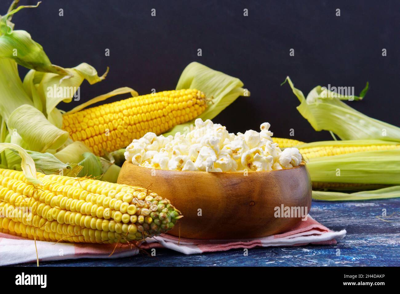 Fresh corn and popcorn on cobs on black background. close up Stock ...