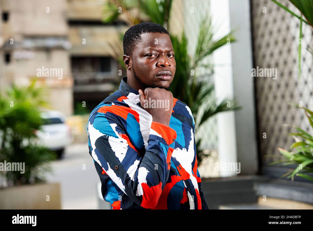 handsome young businessman standing outdoors in the street angry ...