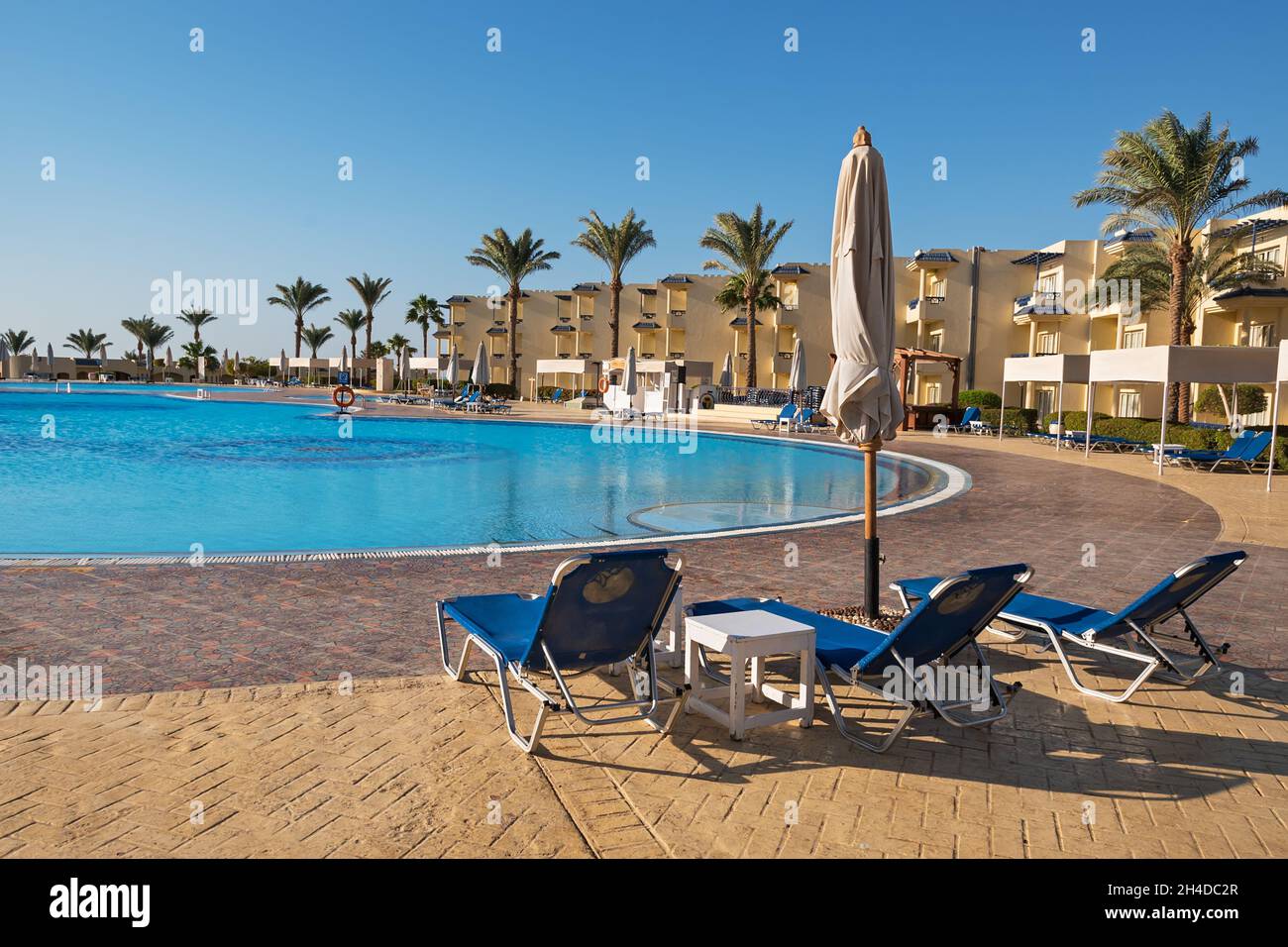 Beautiful swimming pool with palm trees in luxury hotel. Sunny day in ...