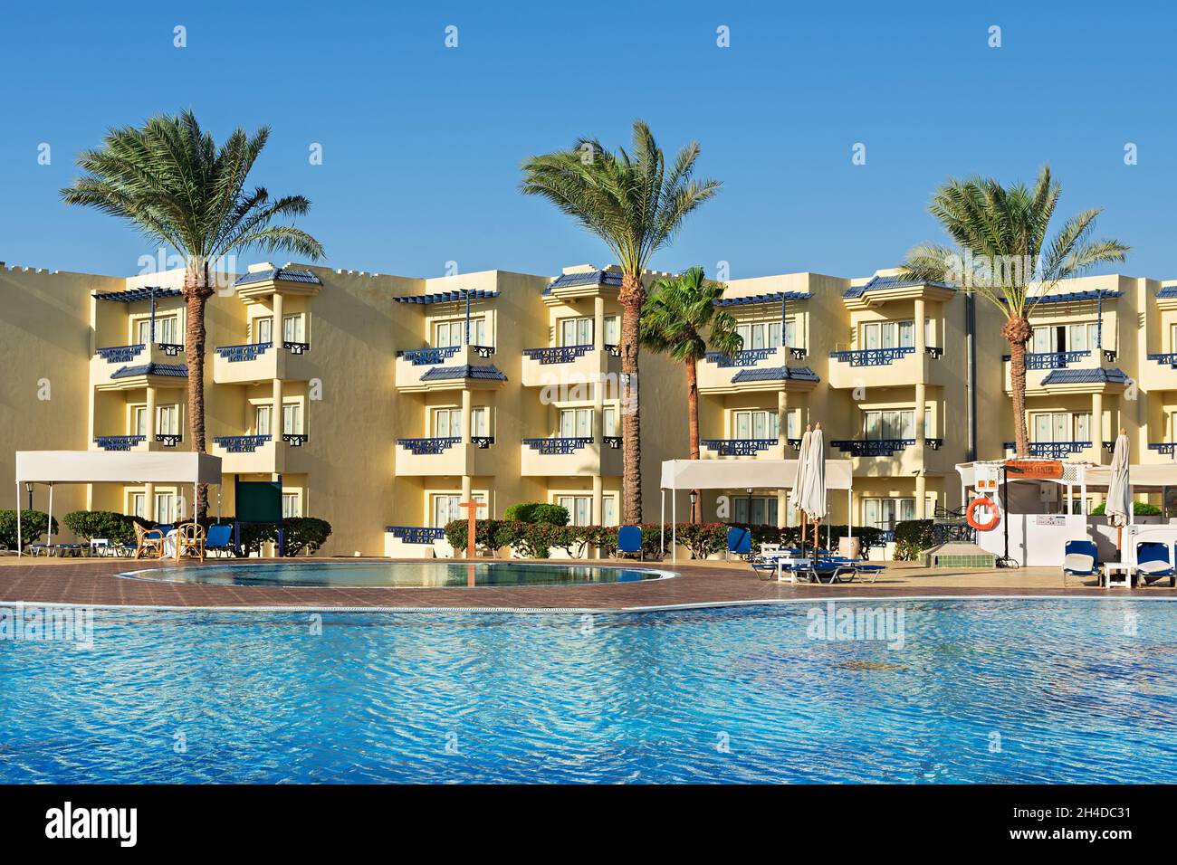Beautiful swimming pool with palm trees in luxury hotel. Sunny day in ...