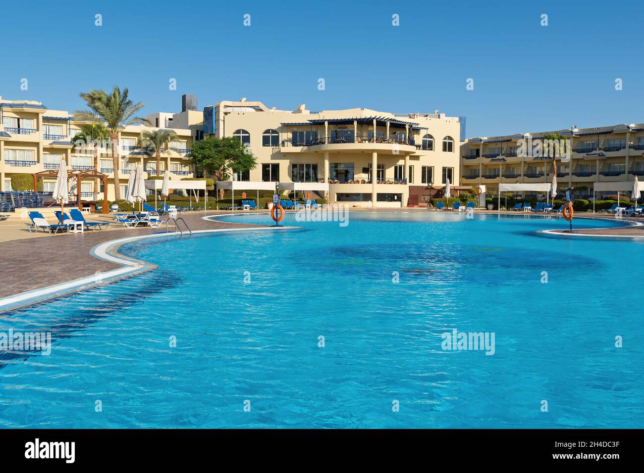 Beautiful swimming pool with palm trees in luxury hotel. Sunny day in ...