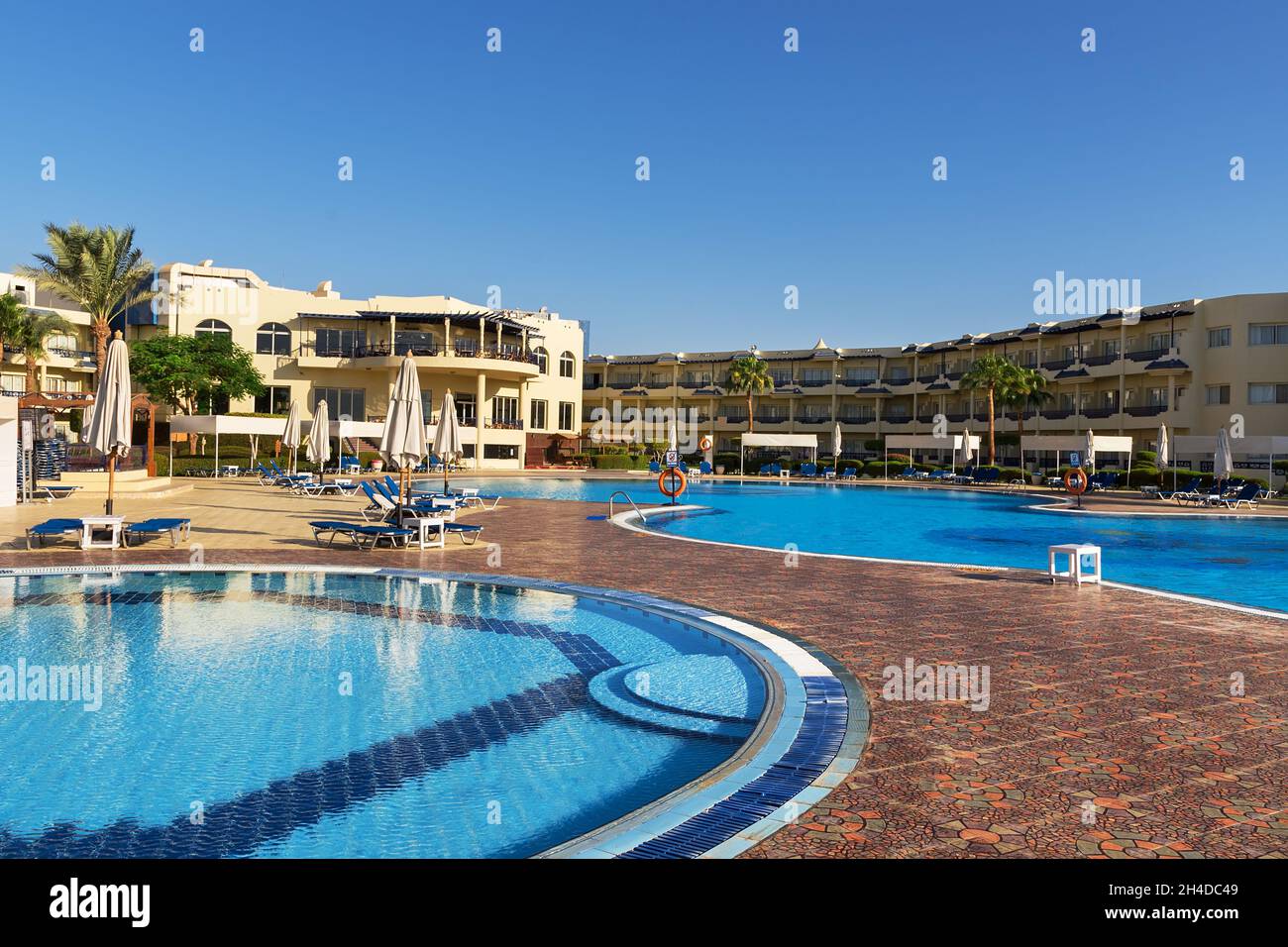 Beautiful swimming pool with palm trees in luxury hotel. Sunny day in ...