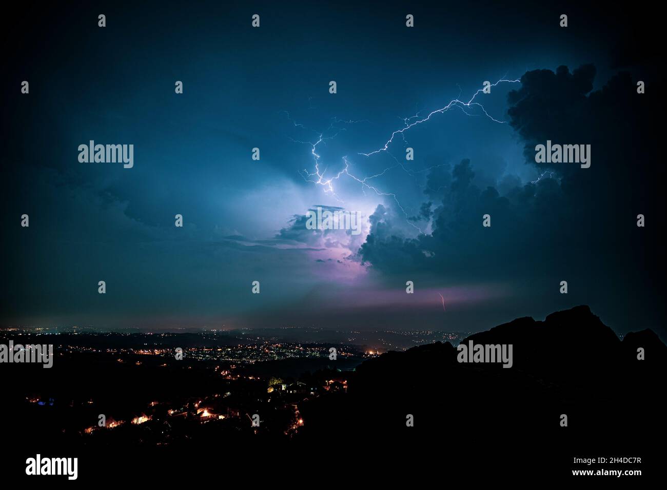 Stunning view of the blue lightning in the night sky above the city ...