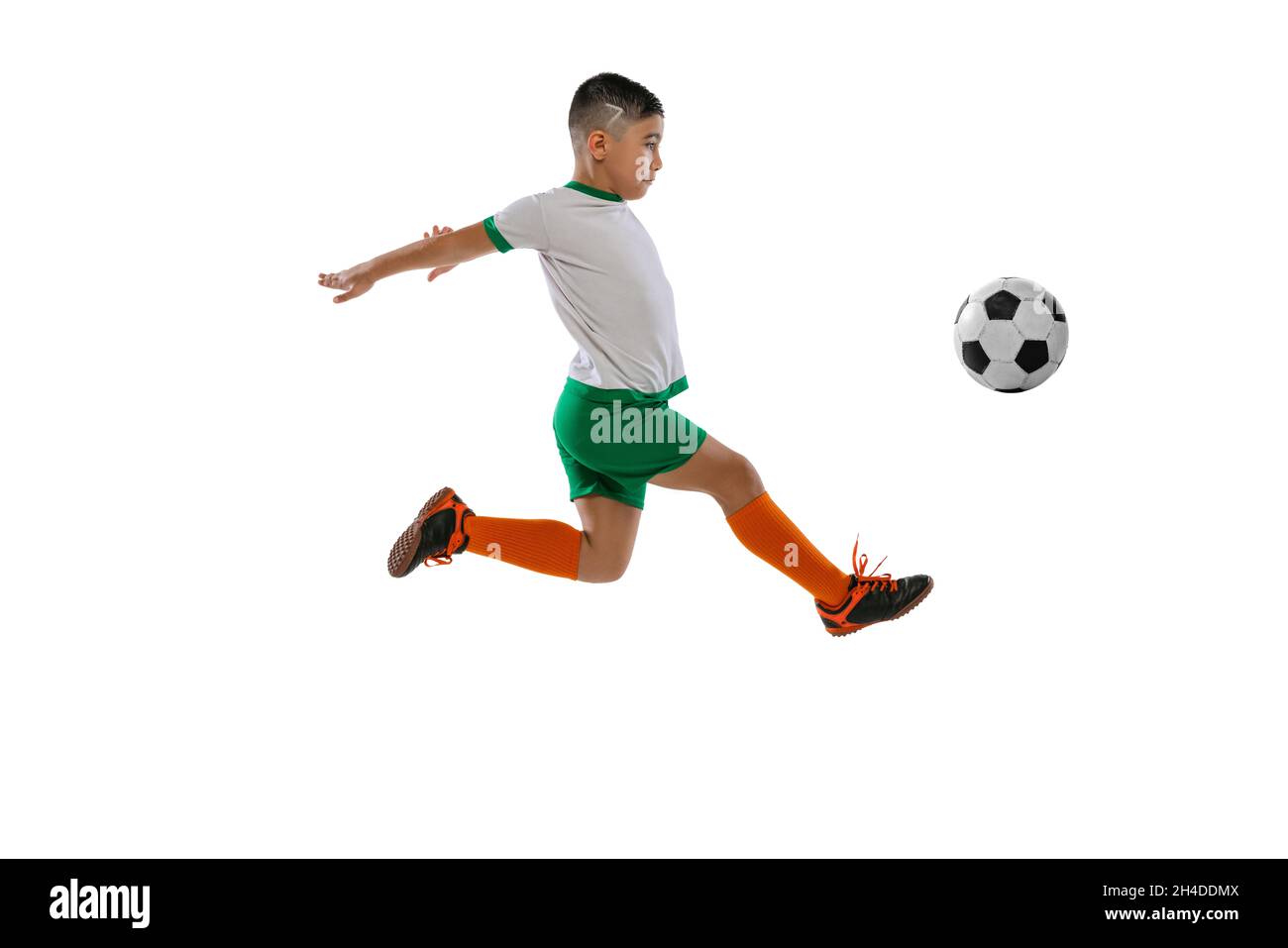 Full-length portrait of boy, child, football player in uniform training ...