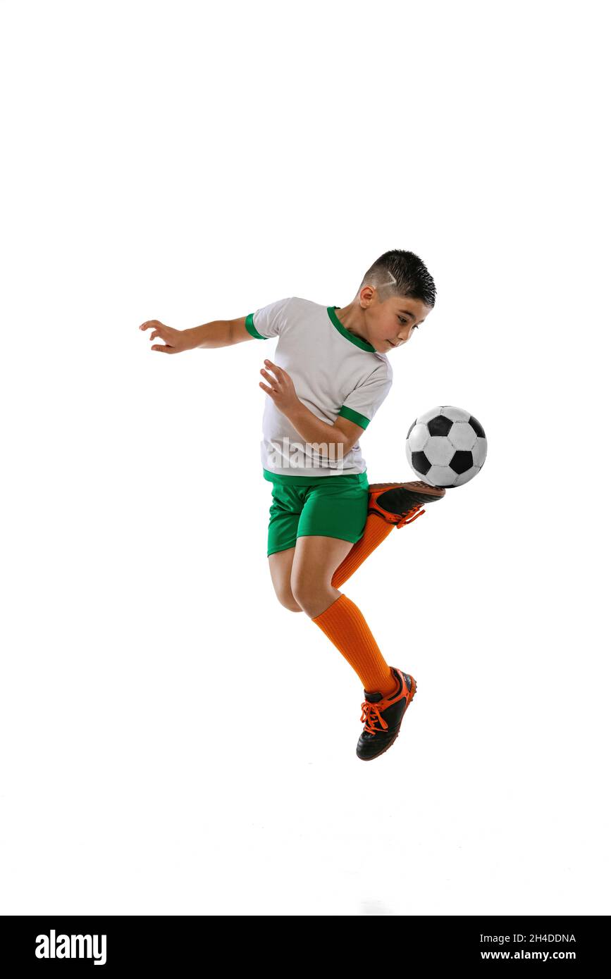 Full-length portrait of boy, child, football player in uniform training ...