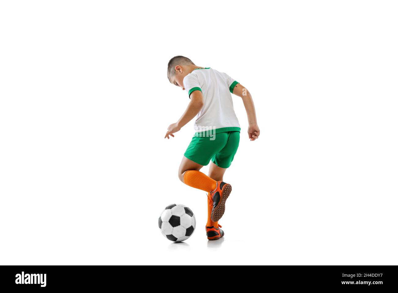 Full-length portrait of boy, child, football player in uniform training ...