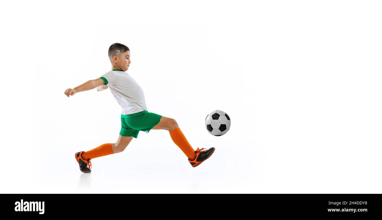 Full-length portrait of boy, child, football player in uniform training ...
