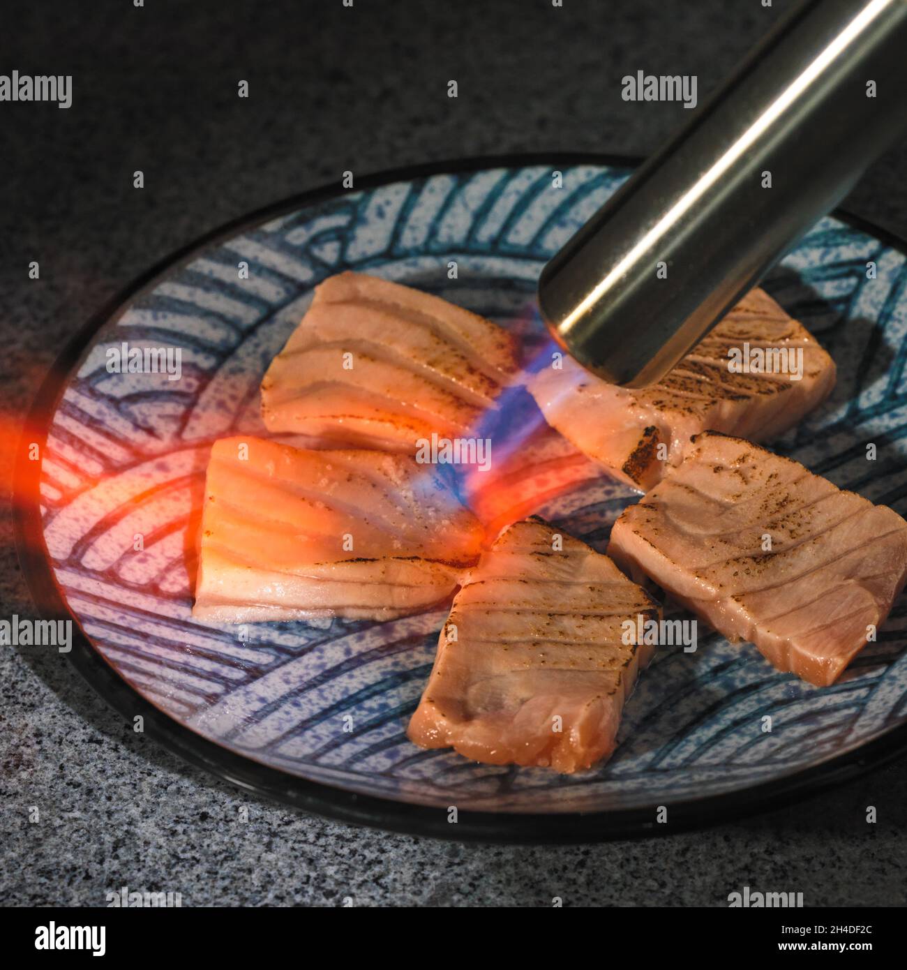 Searing salmon with a blow torch Stock Photo - Alamy