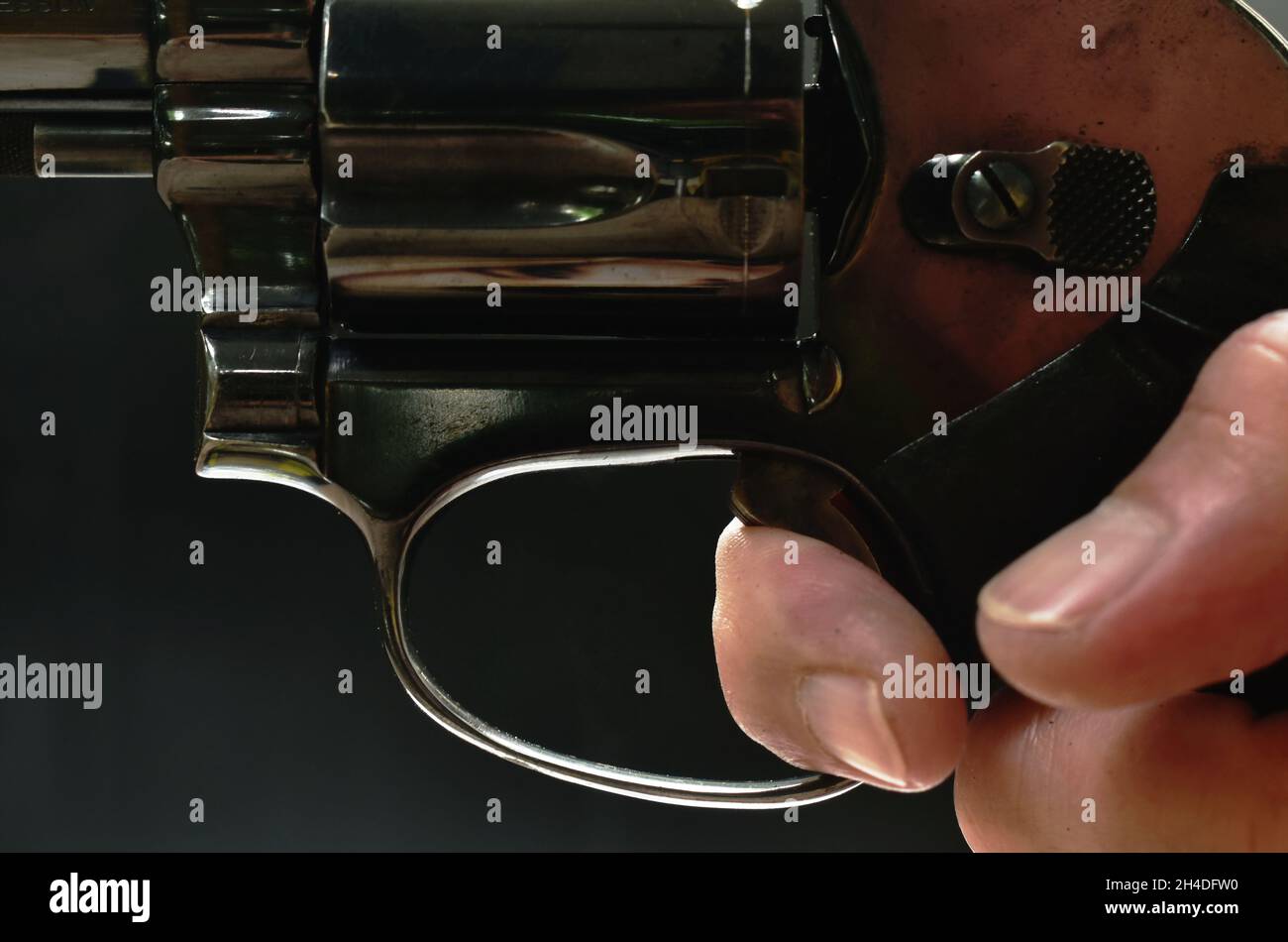 hand holding revolver gun and finger pulling on trigger to shoot black ...