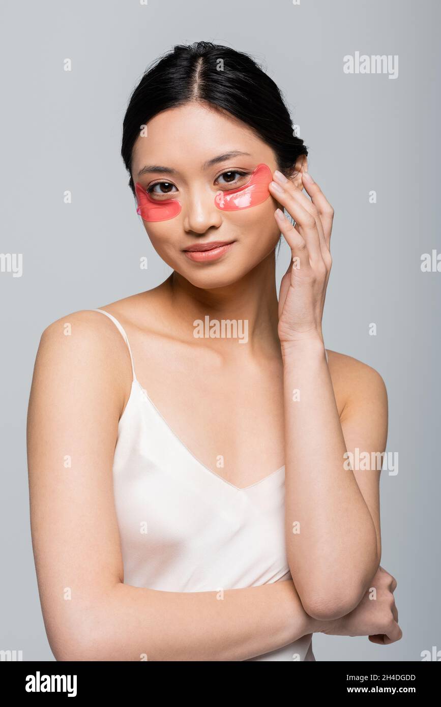 Young asian woman touching eye patch isolated on grey Stock Photo - Alamy
