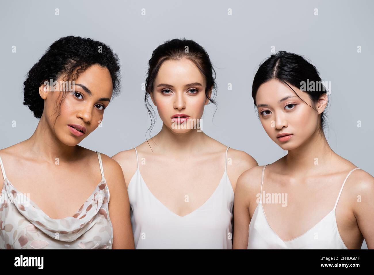 Pretty multiethnic women with perfect skin looking at camera isolated ...