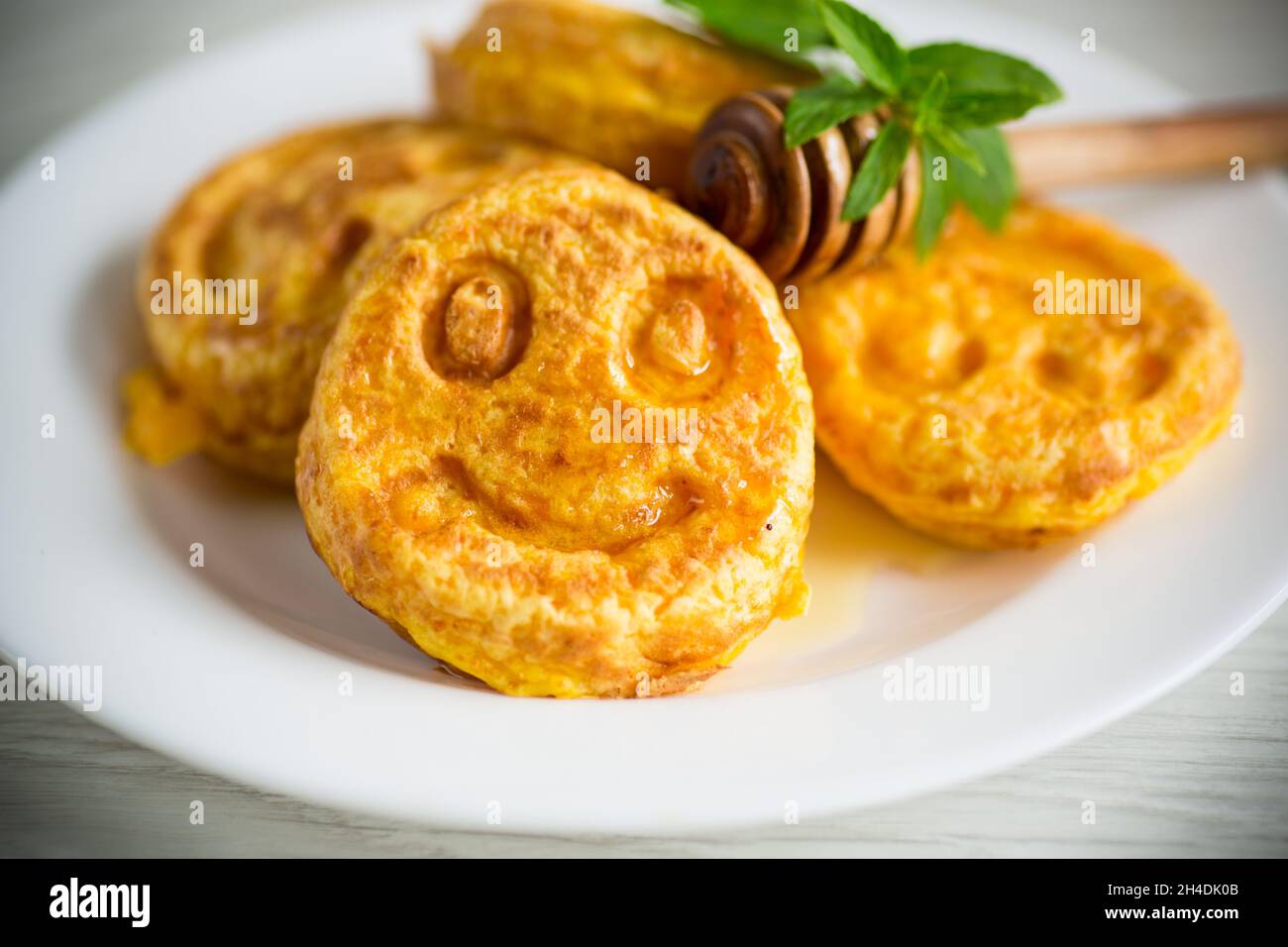 sweet lush pumpkin pancakes with honey in a plate on a wooden table ...
