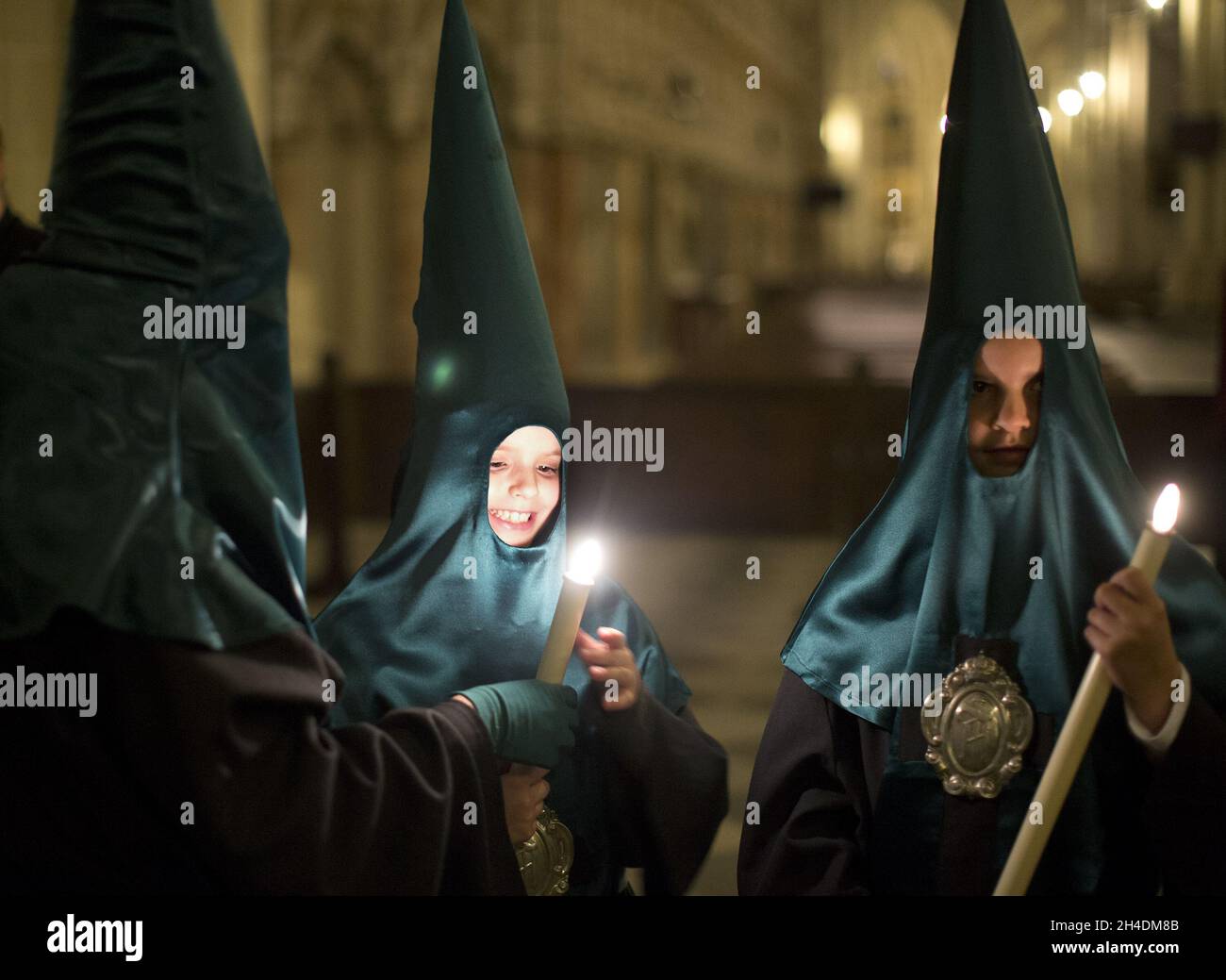 Children wearing capirotes or hoods get ready to take part in the ...