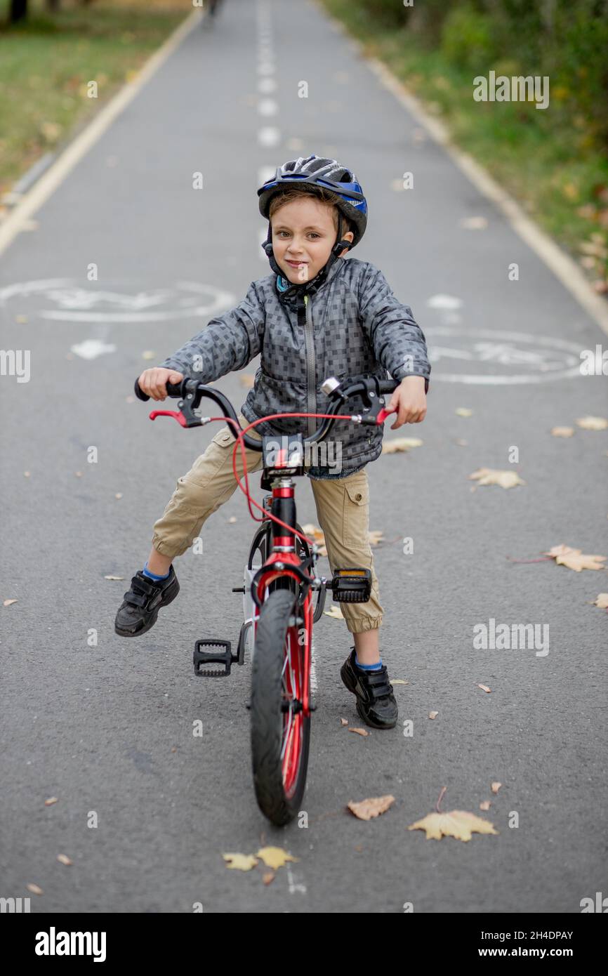 Boy in a helmet on a bicycle rides on a bike path in the park Stock ...