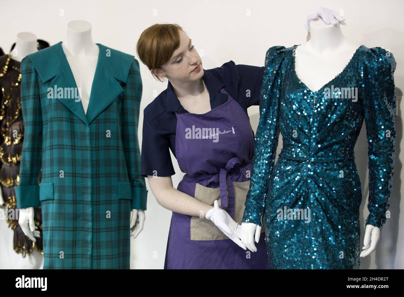 Auction assistant Lucy Bishop puts the finishing touches to two dresses ...