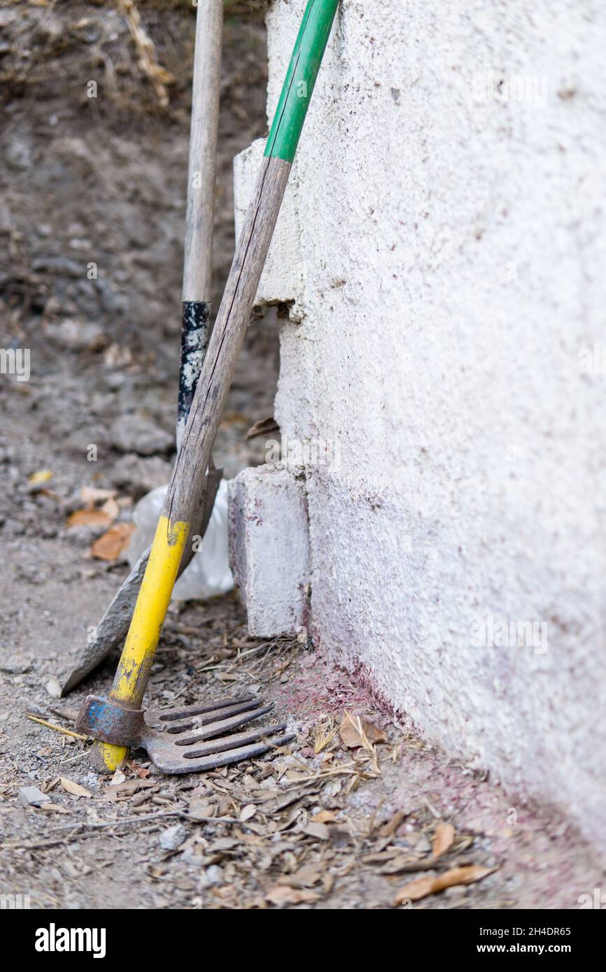 Tools leaning against a wall for working in the field and orchar Stock ...