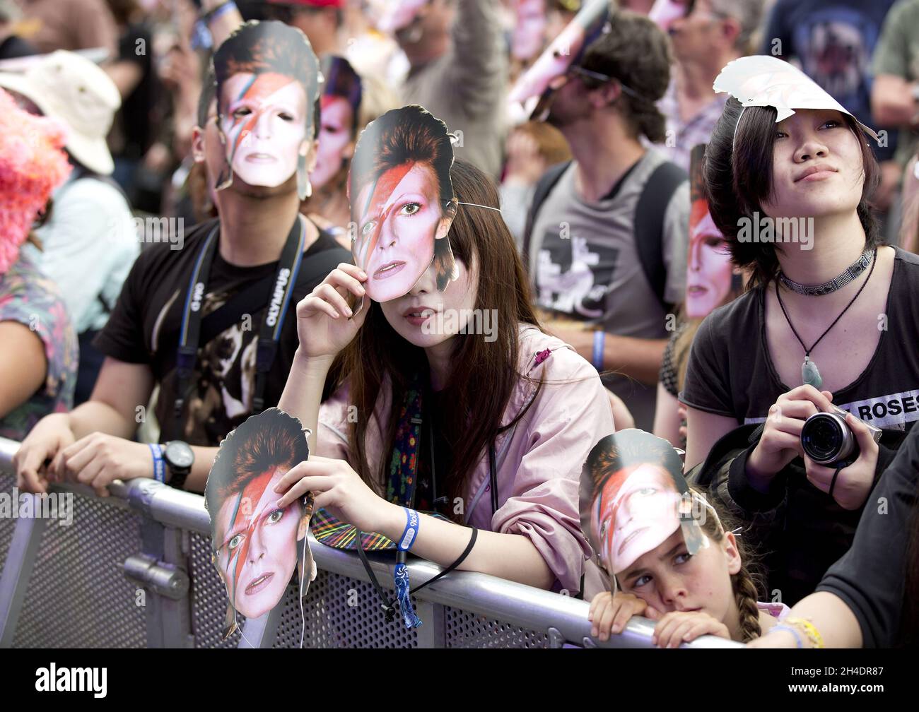 Festivalgoers wear David Bowie masks in tribute to his life and work at ...