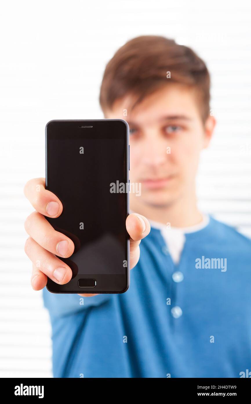 Serious Young Man show a Screen of Mobile Phone in a Room Stock Photo ...
