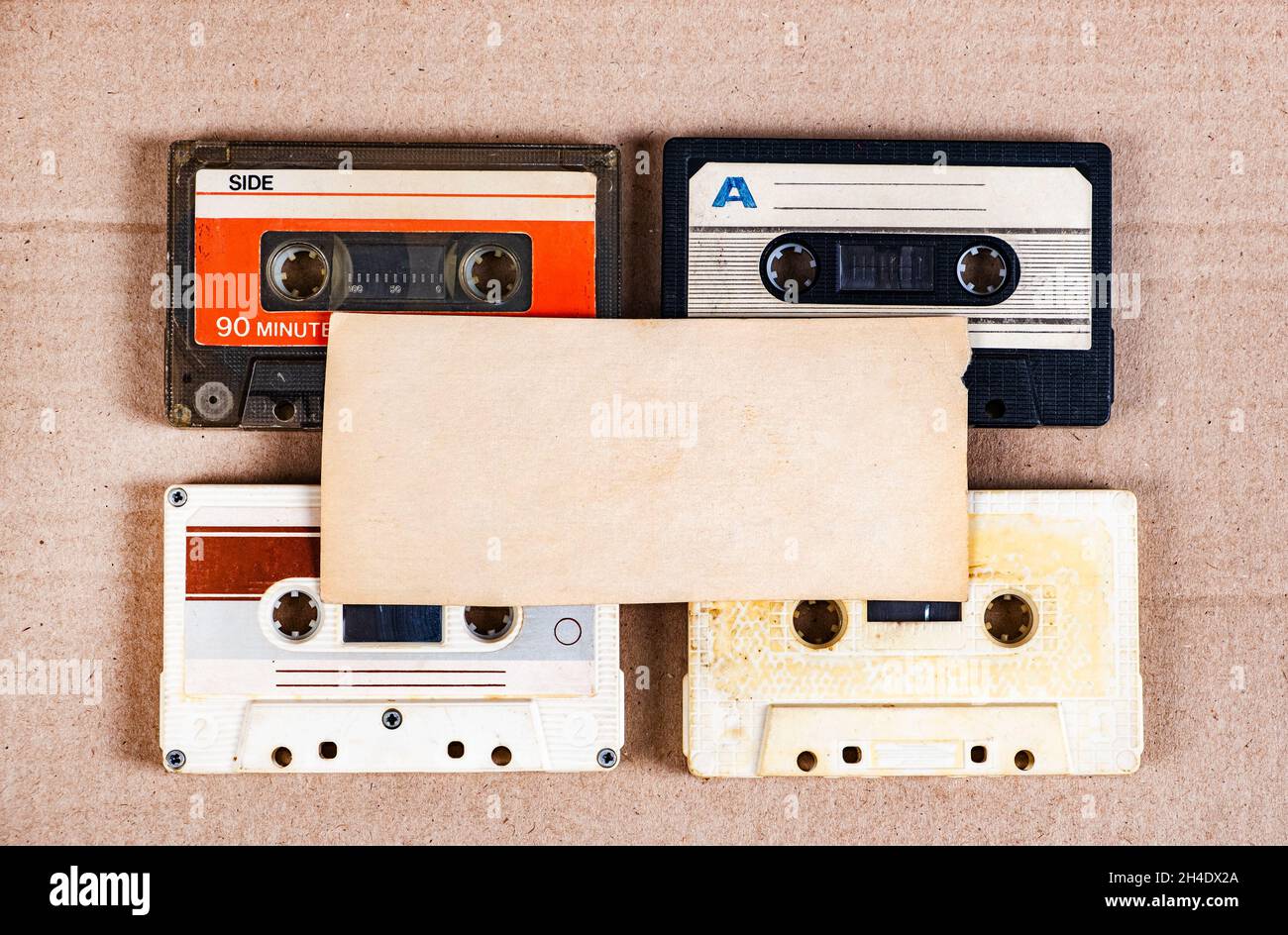 Four Old Audio Cassettes and Empty Paper on the Cardboard Background ...