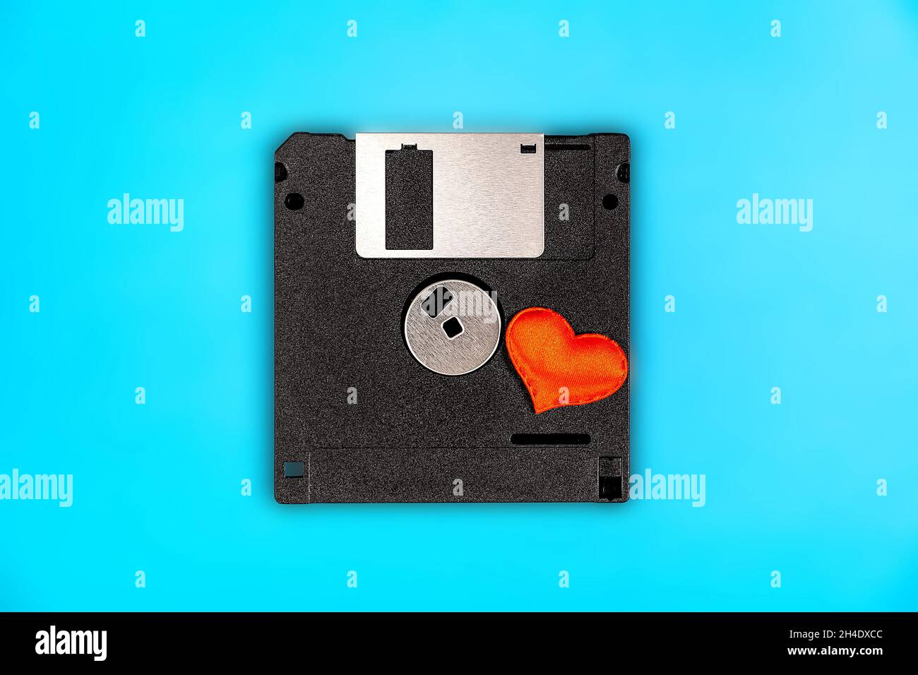 Floppy Disk Drive with a Red Heart on the Blue Paper Background closeup ...
