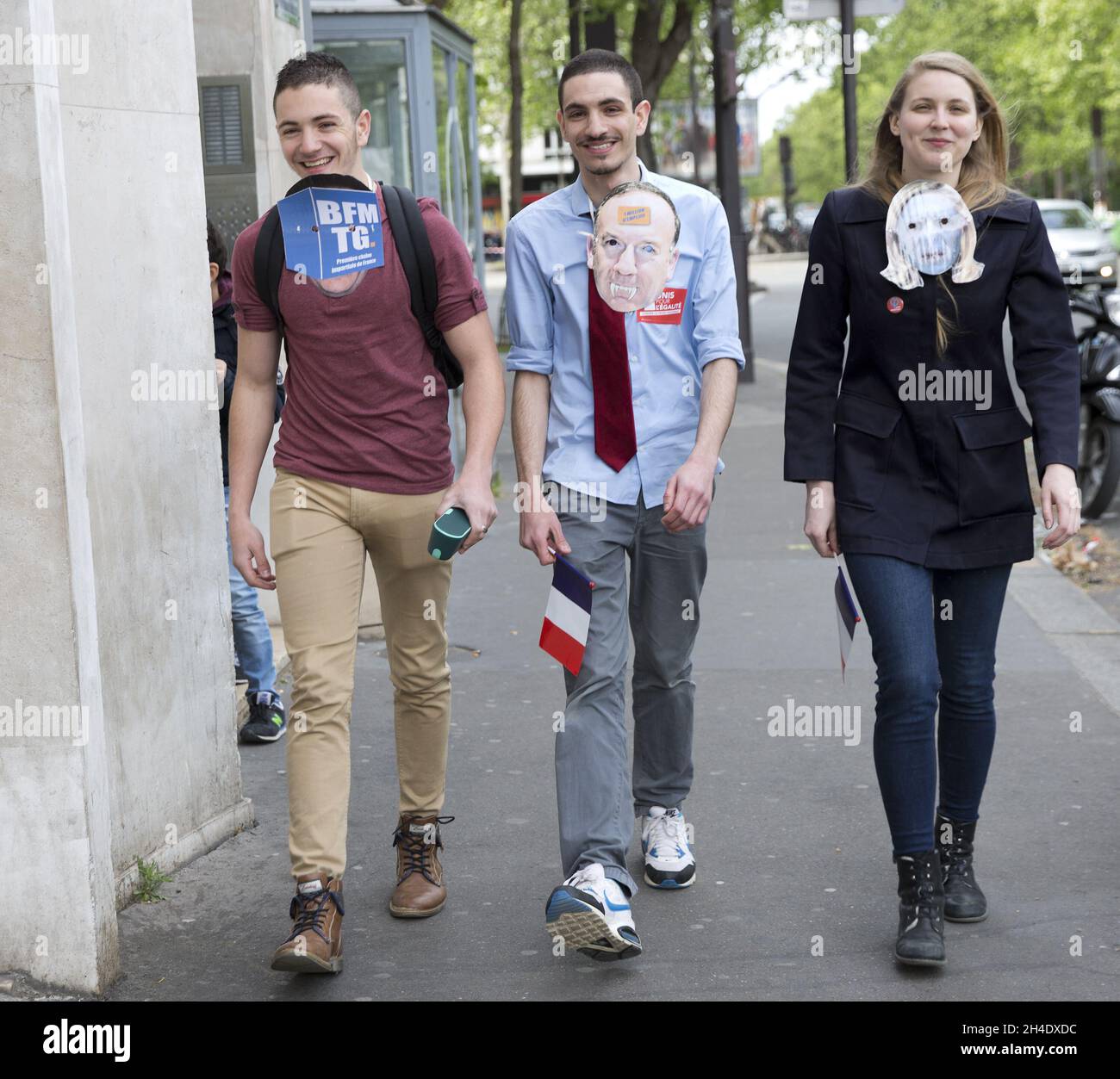 Three young people wear politician face masks during a rally in central ...